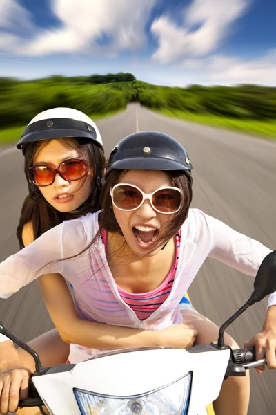 Two girls riding scooter on the road - Stock Image - Everypixel