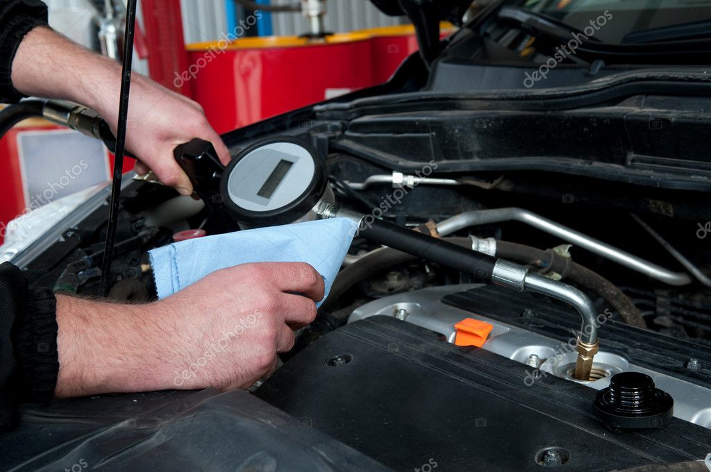 Un hombre reparando un motor de coche 2023
