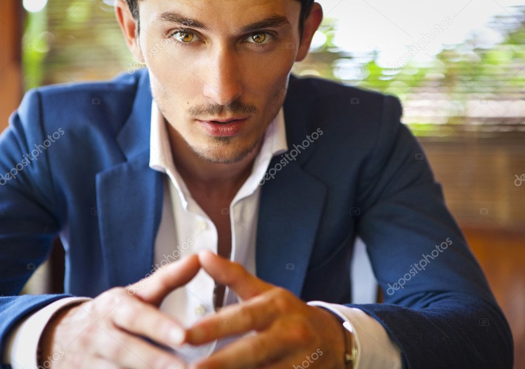 Portrait of a good looking beautiful young man in costume outdoors ...