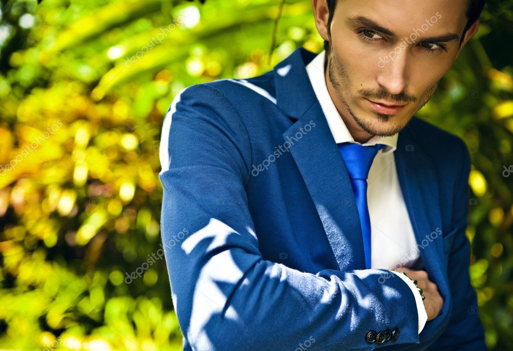 Portrait of a good looking beautiful young man in costume outdoors ...