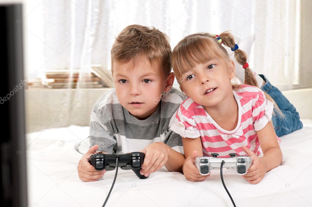 Happy girl and boy playing a video game — Stock Photo © DenisNata #10030551