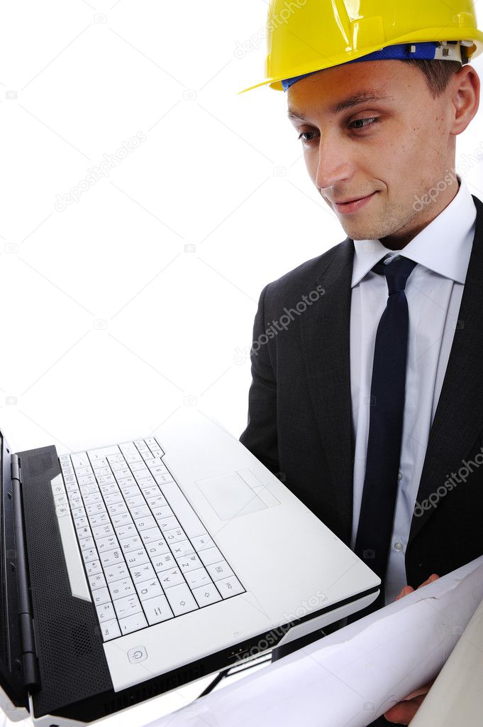 Construction engineer using his laptop computer and blueprints in the ...