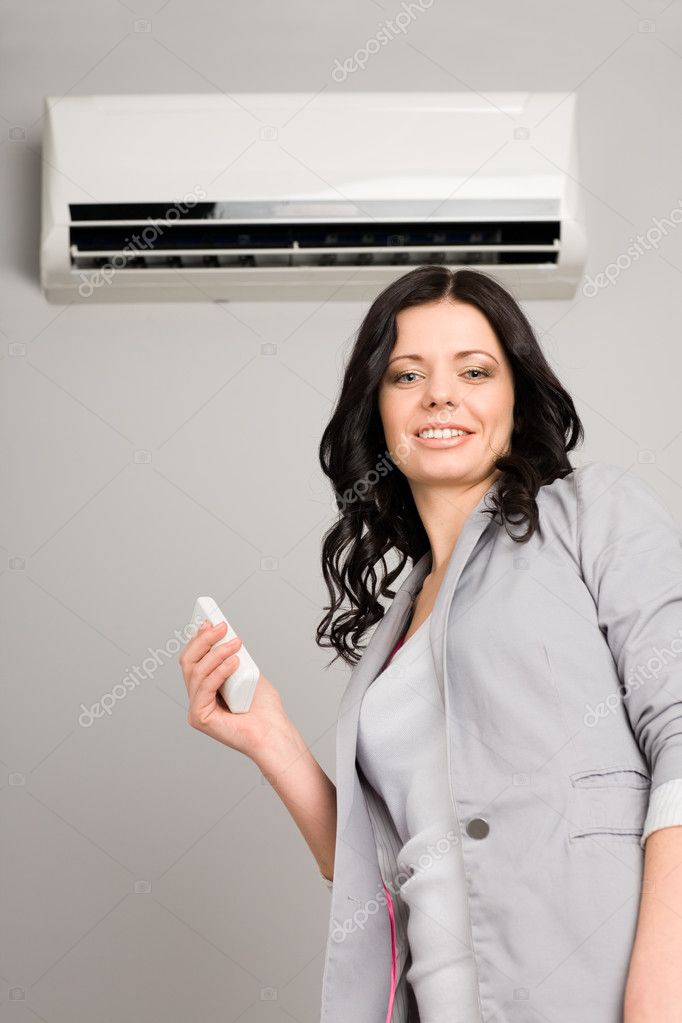 Girl with a remote control air conditioner — Stock Photo © Stas_K #9093701