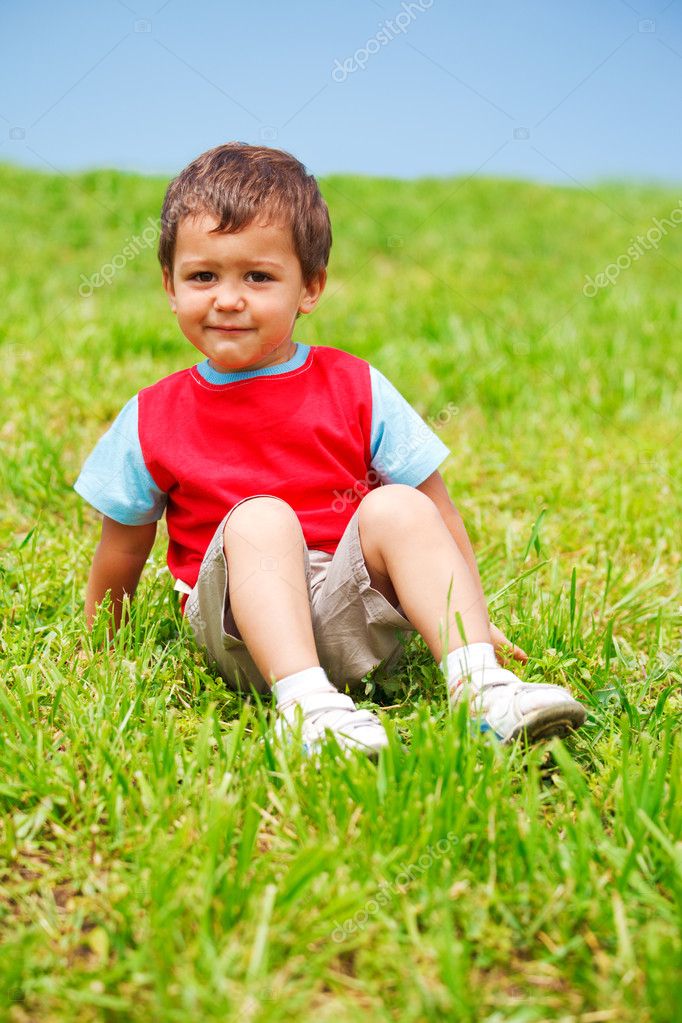 Boy sitting on grass Stock Photo by ©anatols 8691723