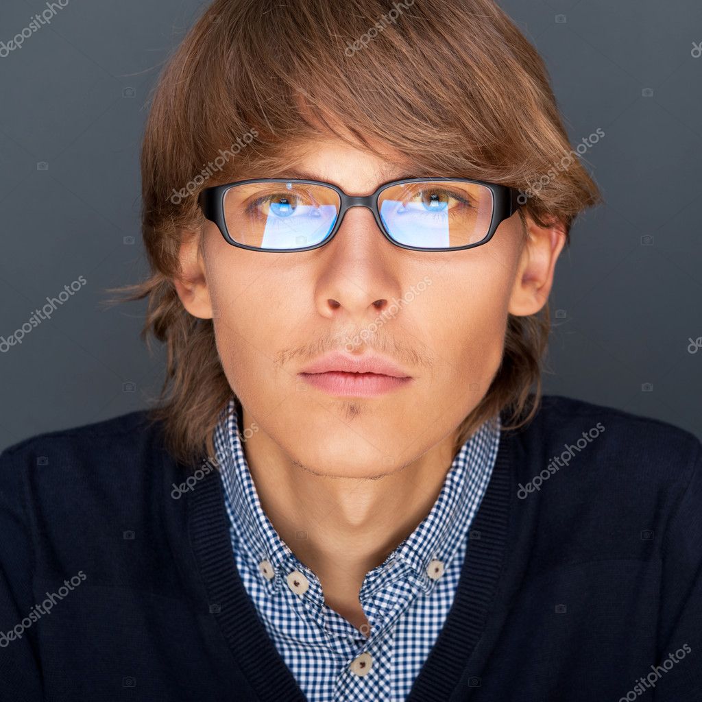 Portrait of young man with smart and wise look. Looking at camer ...