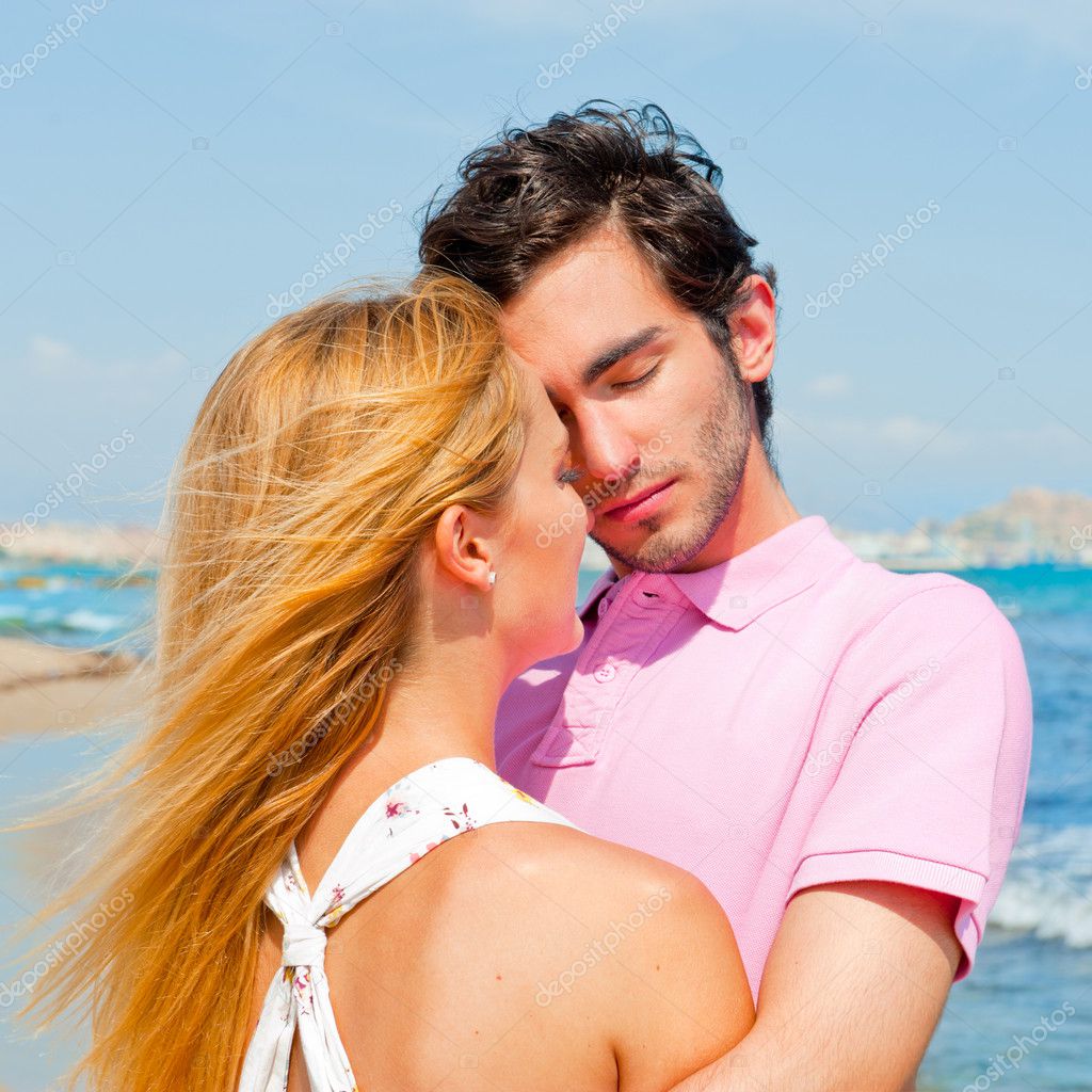 Retrato de pareja joven enamorada abrazándose en la playa y disfrutando 2022