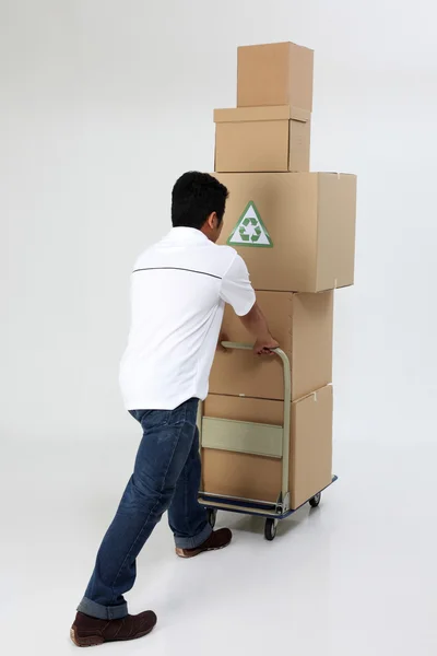 Delivery man pushing a trolley with boxes Stock Photo by ©eskaylim 9159598