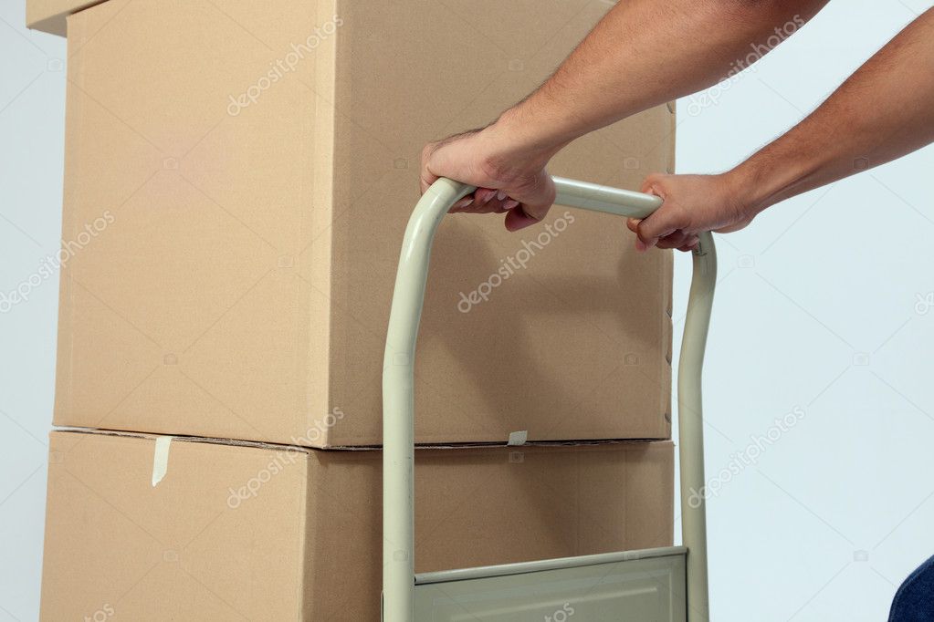 Delivery man pushing a trolley with boxes Stock Photo by ©eskaylim 9159598