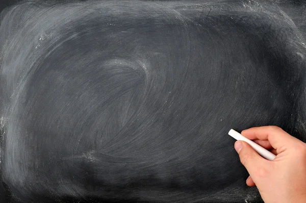 Smudged blackboard background with a hand holding chalk writing. ⬇ ... Smudged blackboard background with a hand holding chalk writing. ⬇ ...