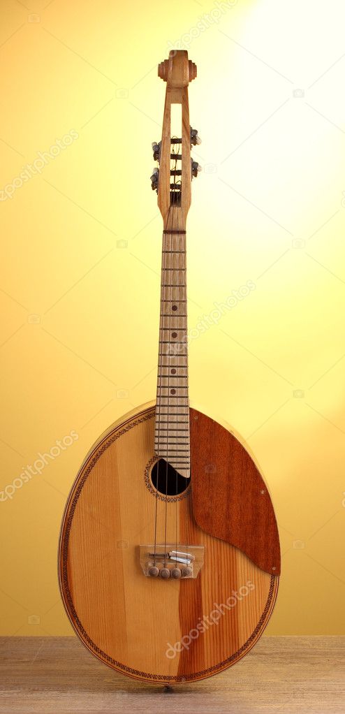Retro kobza- Ukrainian musical instrument on wooden table on yellow ...
