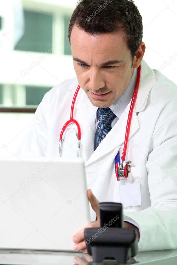 A doctor looking at his laptop — Stock Photo © photography33 #10198615 A doctor looking at his laptop — Stock Photo © photography33 #10198615