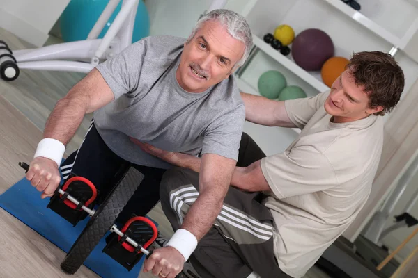 Older man exercising with a personal trainer - Stock Image - Everypixel