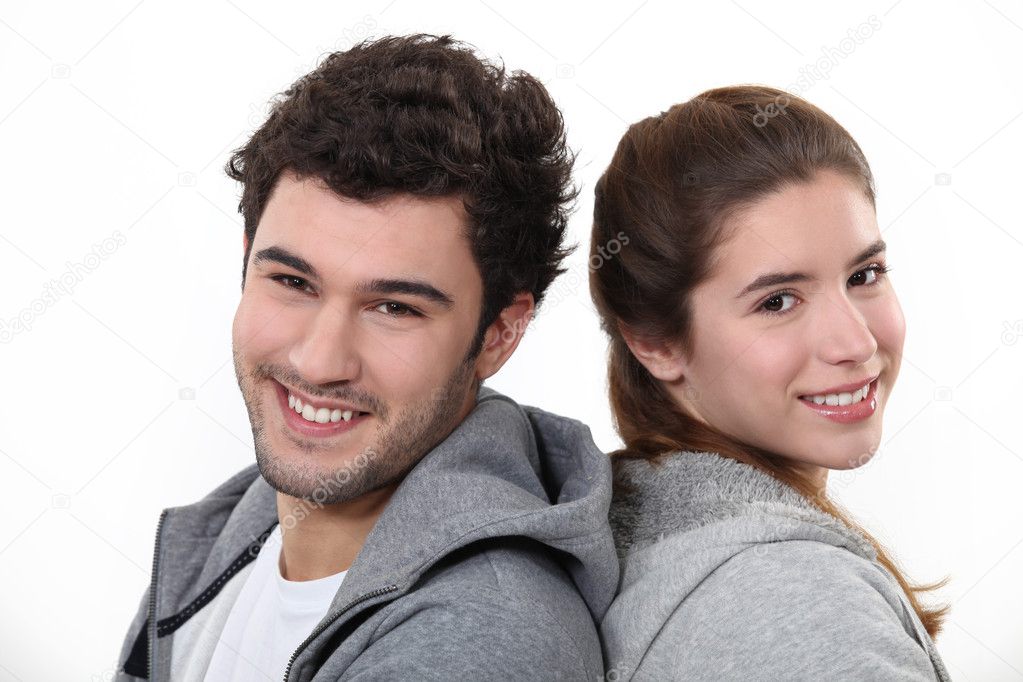 Portrait of a young man and woman standing back to back — Stock Photo ...