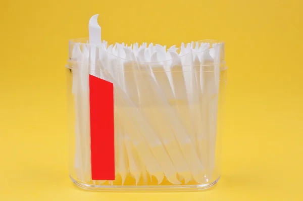 Toothpicks in clear plastic container on yellow - Stock Image - Everypixel