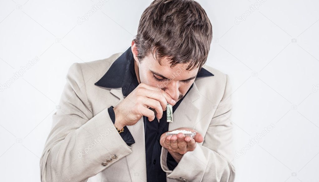 Drug addicted young man doing coke with rolled up dollar in retro suit ...